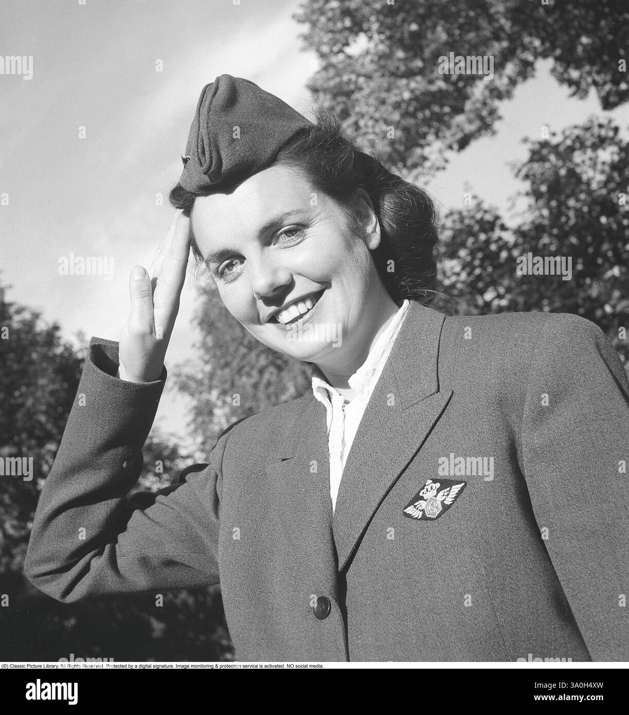 Flight attendant 1946. She looks at the camera, makes a salute and ...