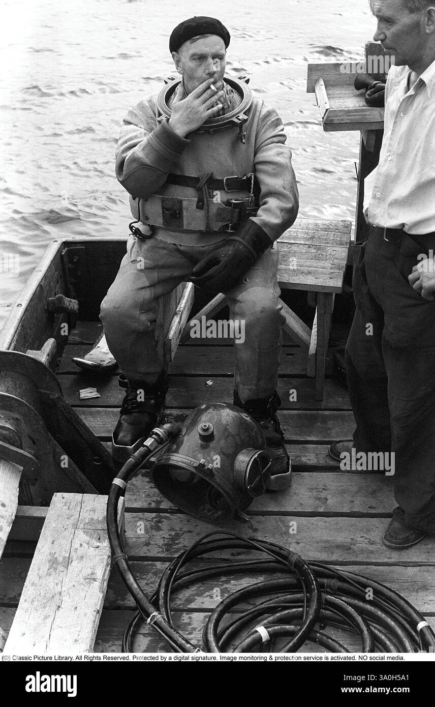 A diver in 1953, sitting in his diving suit and smoking a cigarette ...