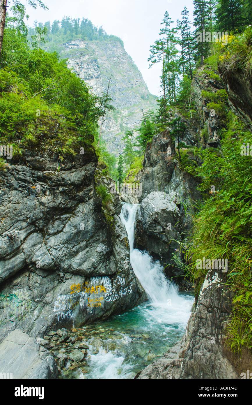 This image captures a small but vibrant waterfall cascading between ...