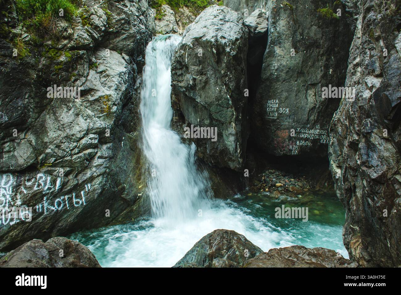 This image captures a small but vibrant waterfall cascading between ...