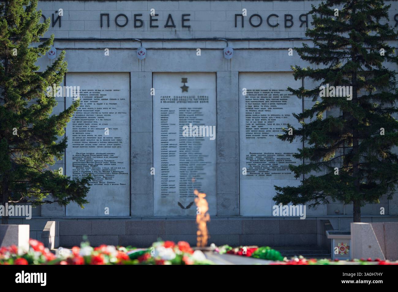 Memorial wall with engraved names and an eternal flame, surrounded by ...