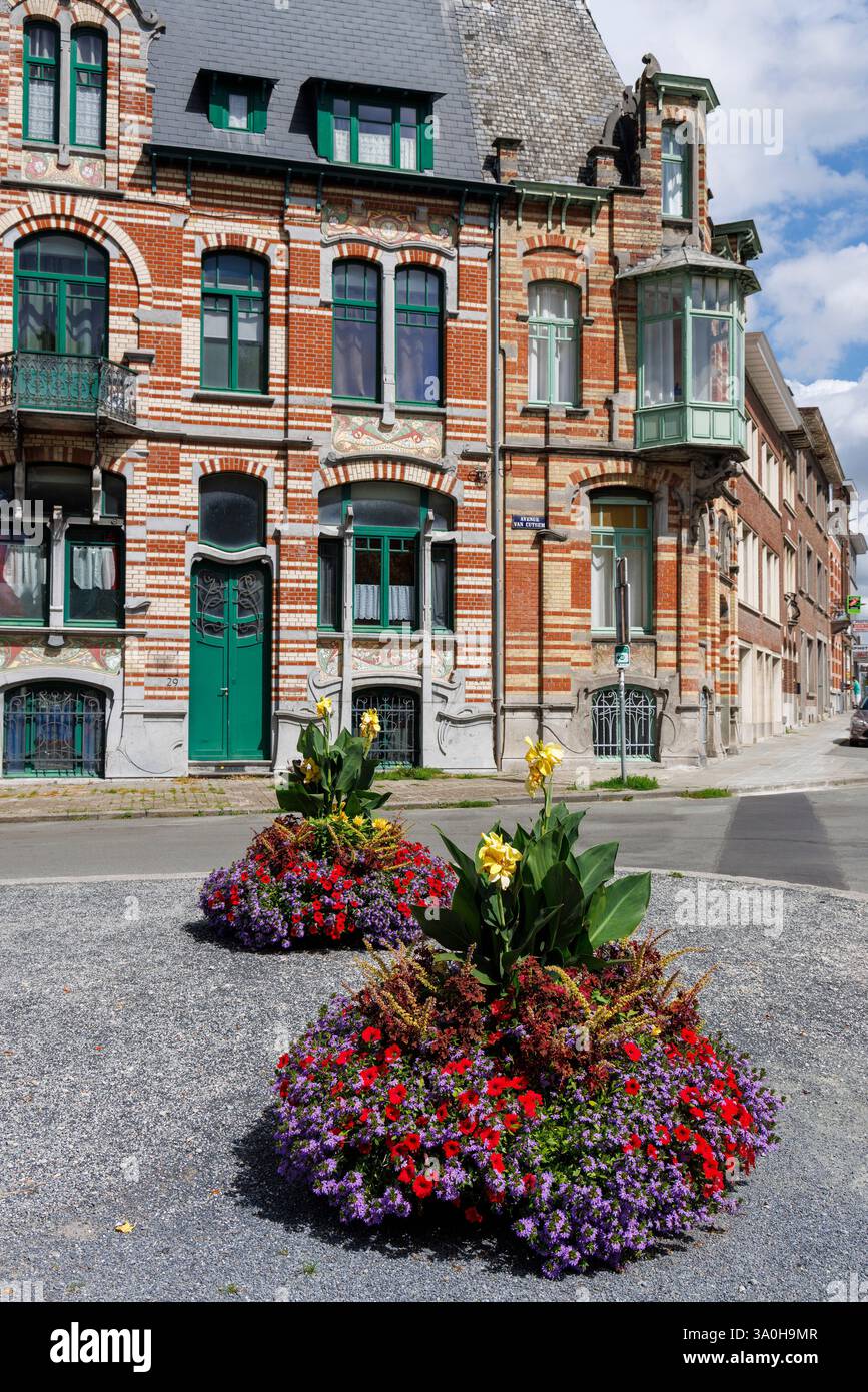 Flowers growing in front of old house with balcony and turret, Tournai ...
