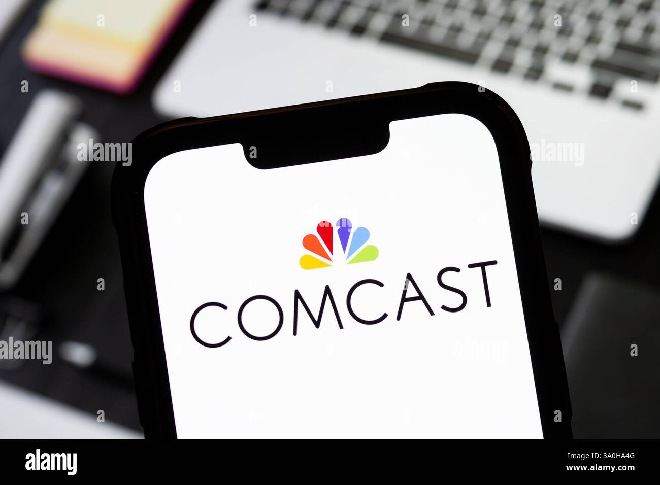 In this photo illustration, a Comcast logo is seen displayed on a ...