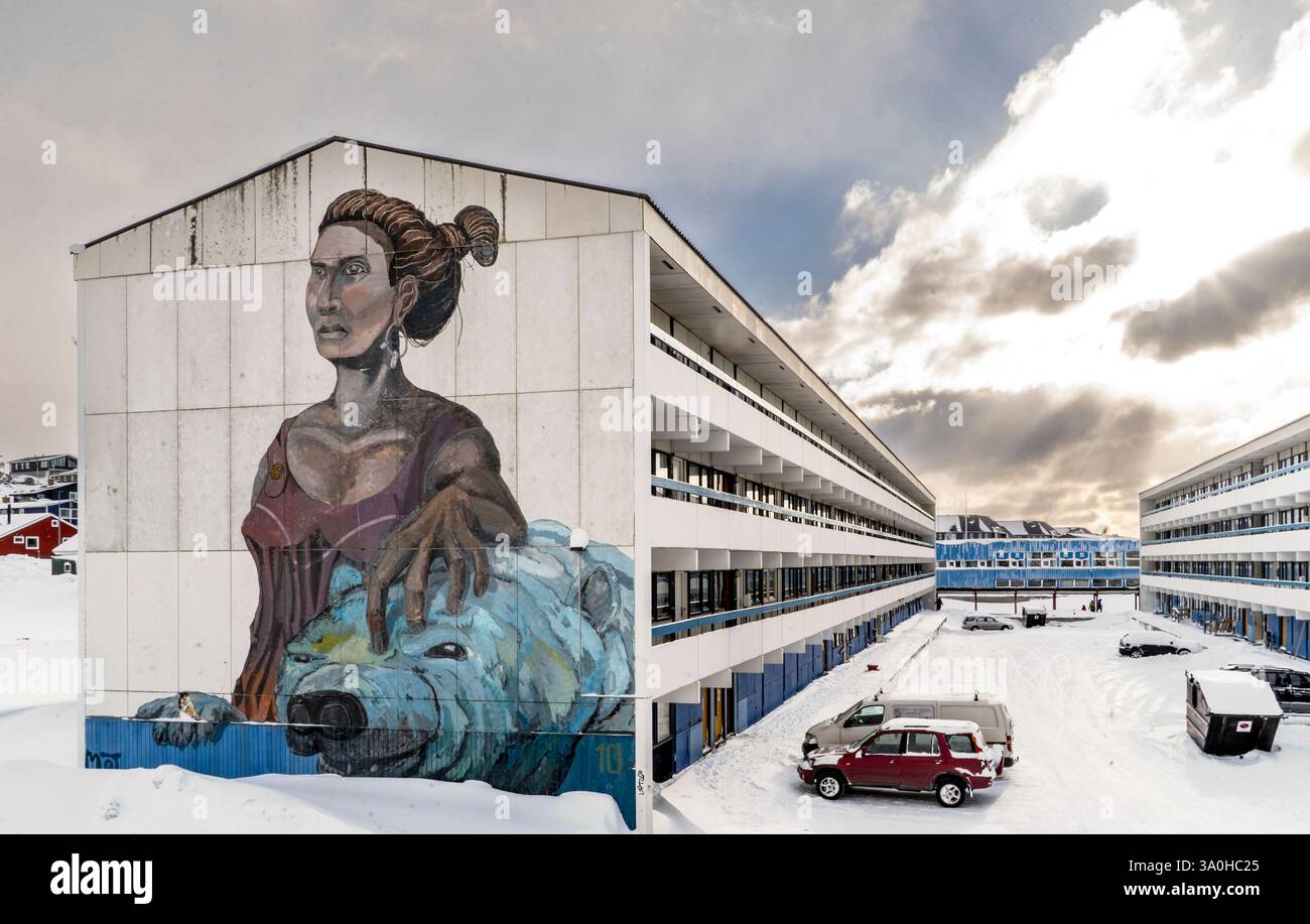 A large mural depicting a woman with a polar bear on the side of a ...
