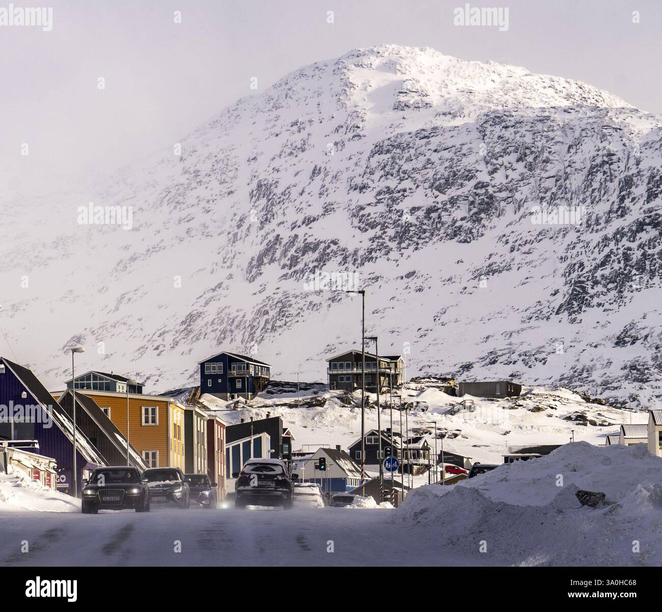 A snowy street scene in a mountainous area, featuring colorful houses ...