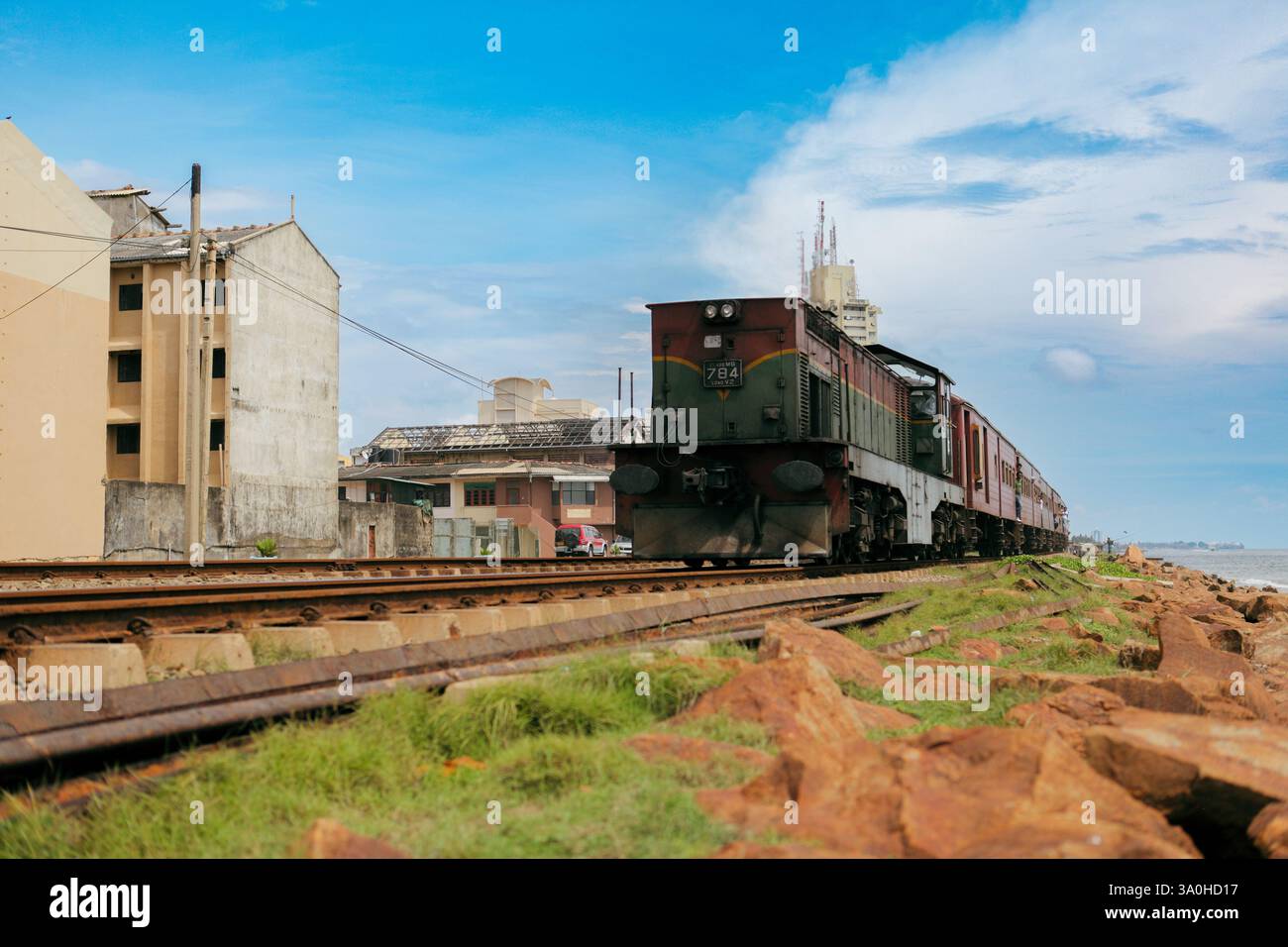 A train moves swiftly along the coastal railway tracks in Colombo ...