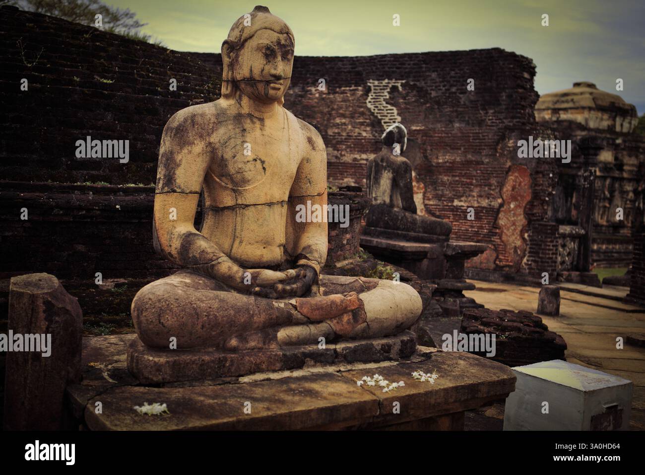 A serene Buddha statue sits in peaceful meditation at an ancient site ...
