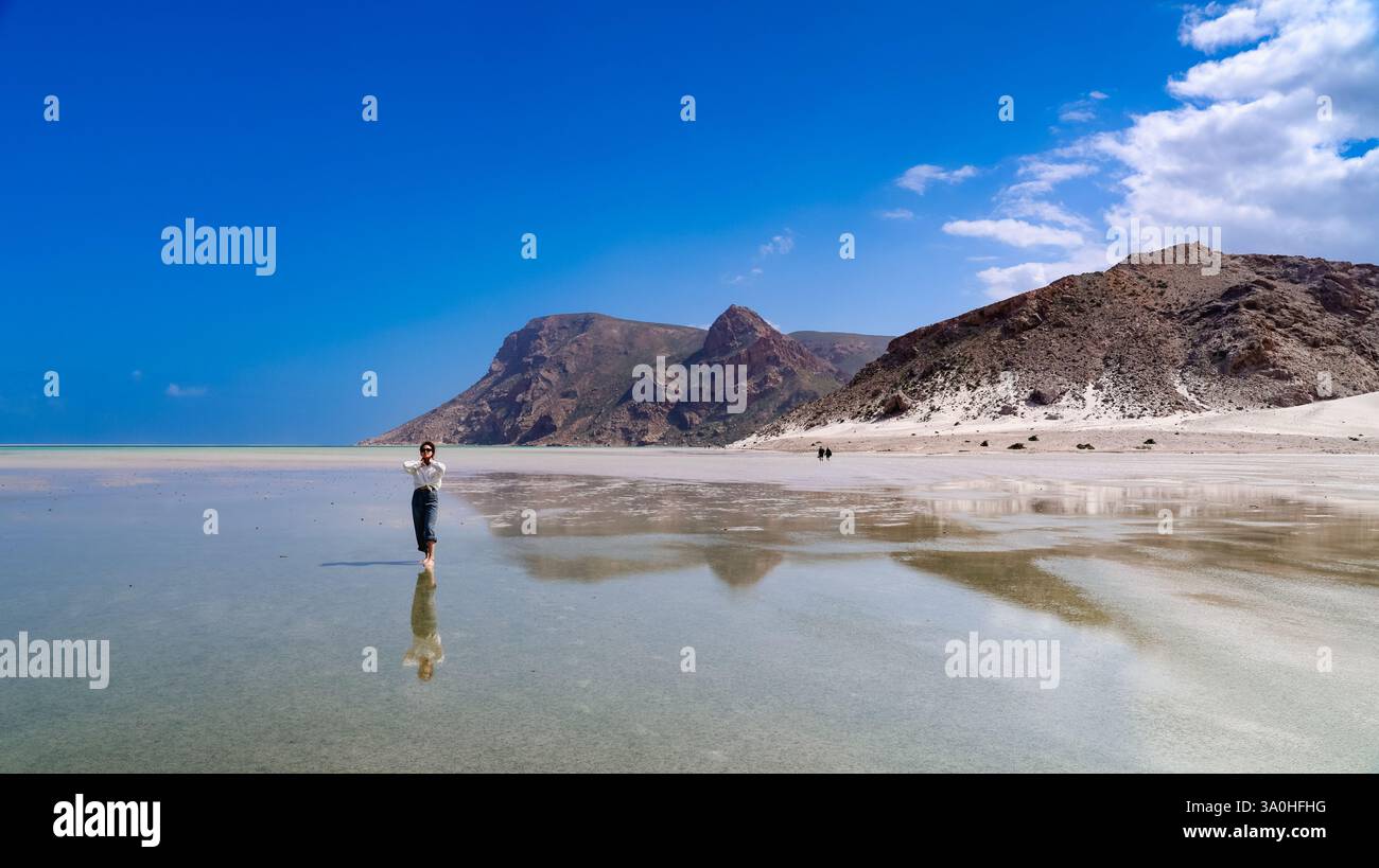 A tourist stands in shallow water on Socotra Island, surrounded by ...