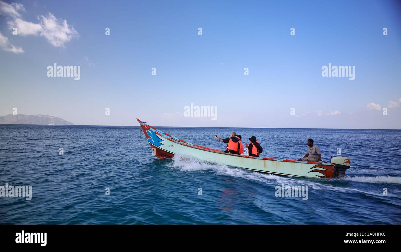 Tourists enjoy a boat ride in the crystal clear waters of Socotra ...