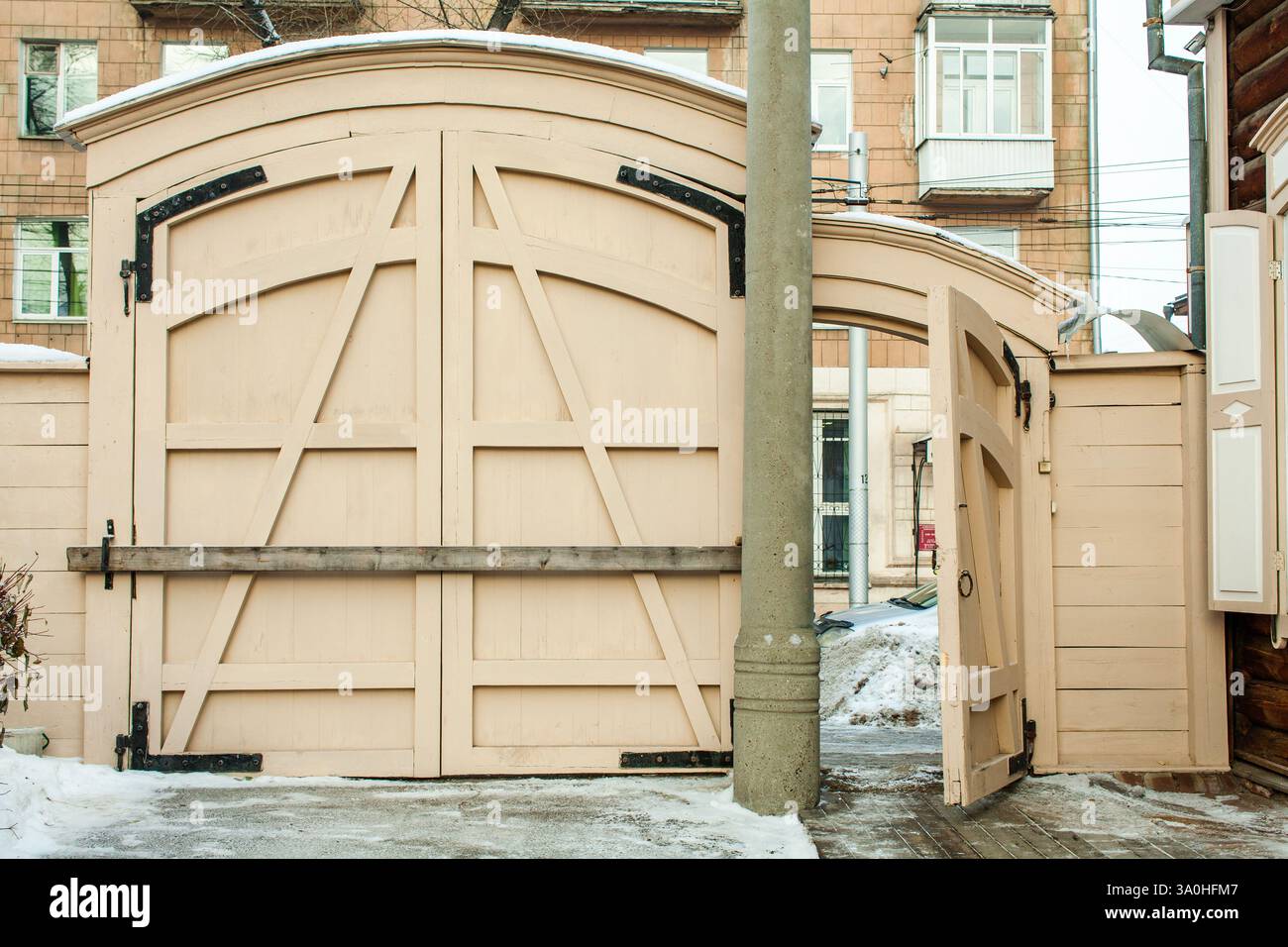 A close-up view of a large wooden gate in a winter setting, painted in ...