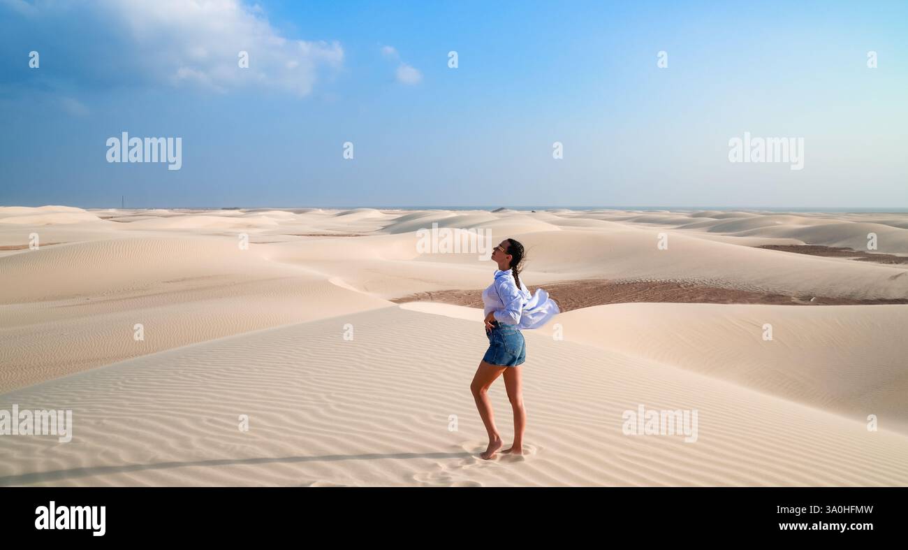 A tourist walks gracefully across the unique sand dunes of Socotra ...