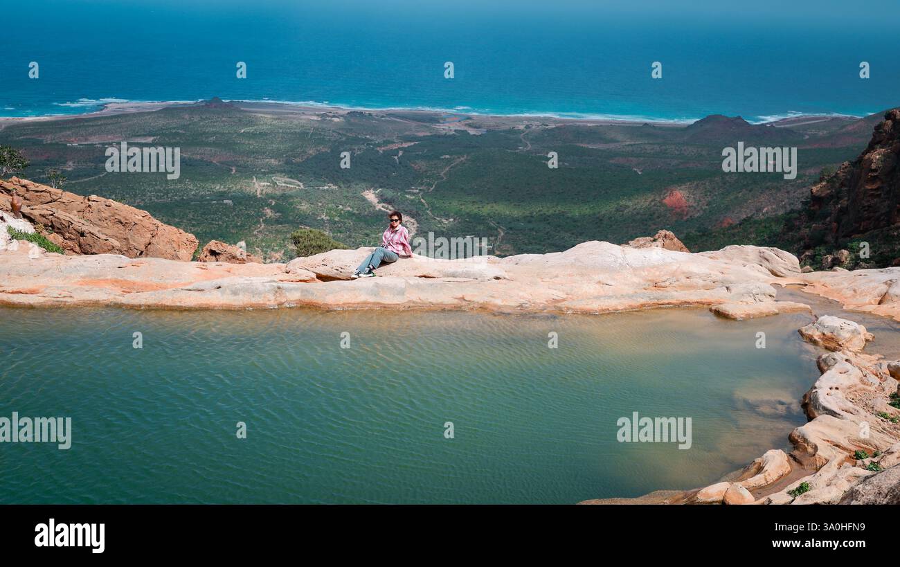 A tourist relaxes by a natural pool on Socotra Island, taking in the ...