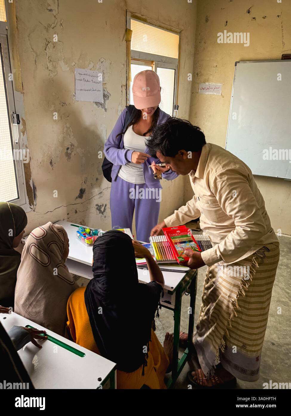 Tourist interacts with local children in a Socotra classroom, helping ...