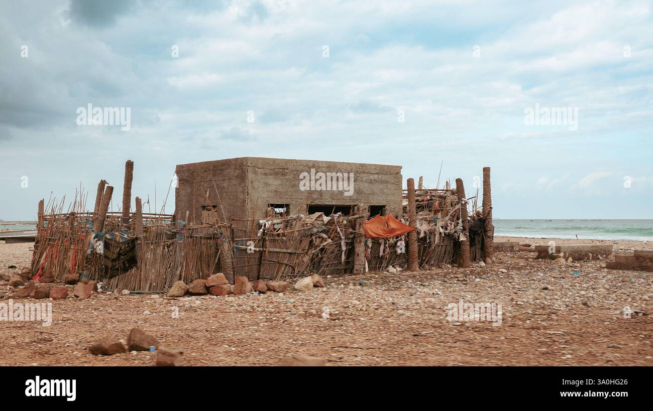 Rustic structures made of natural materials stand near the shoreline of ...