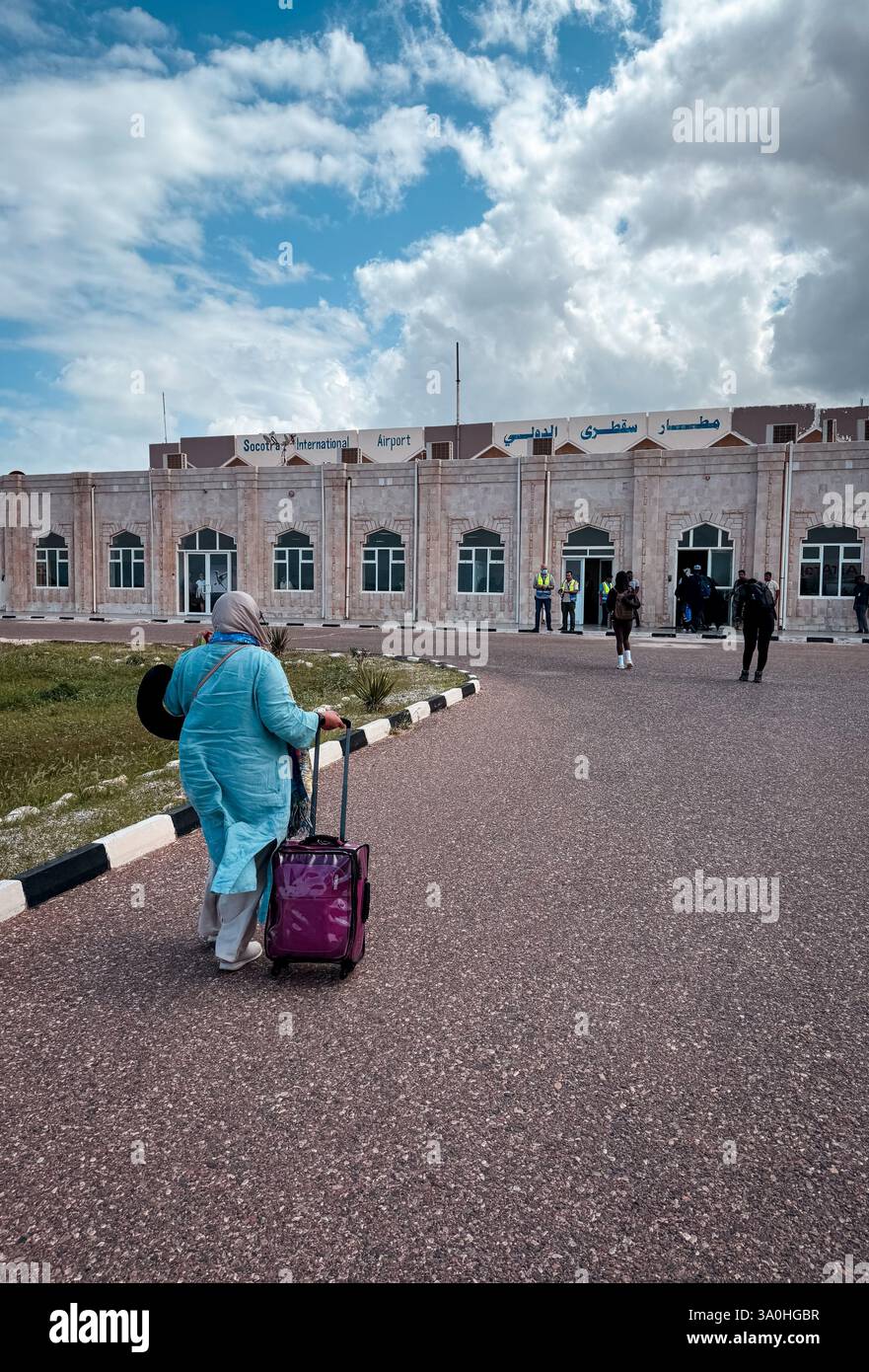 Travelers arrive at Socotra Islands airport carrying luggage against a ...