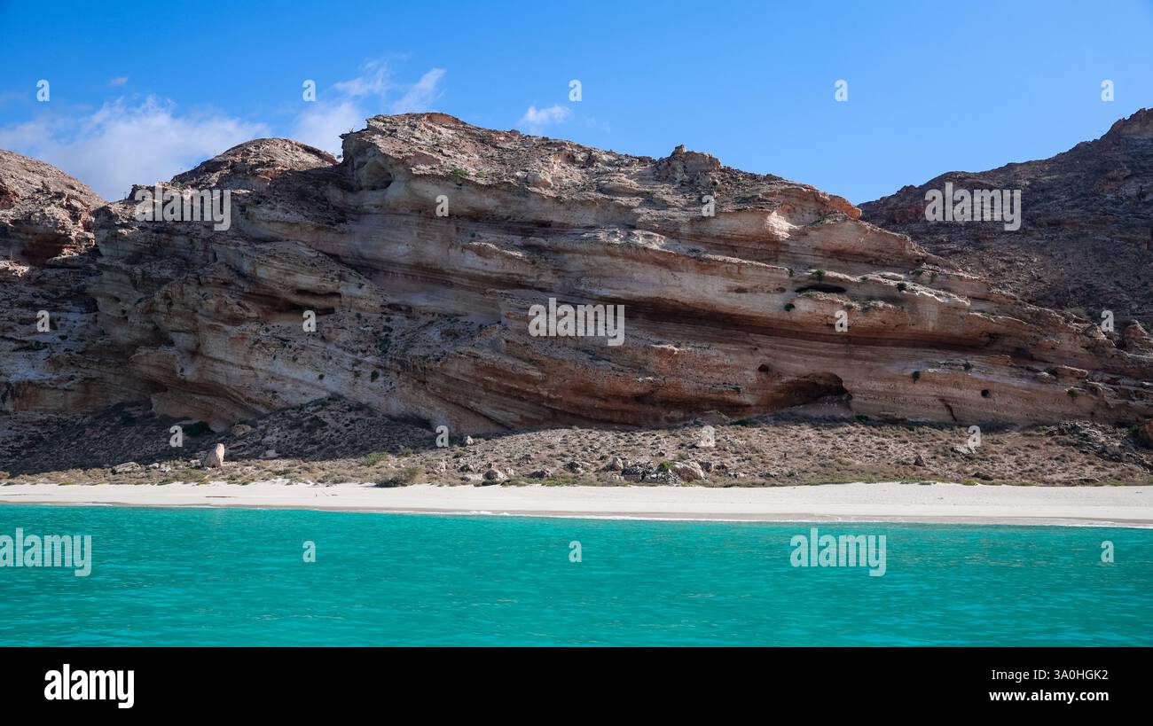 Turquoise waters gently lap against the shore of Shoab Bay, framed by ...