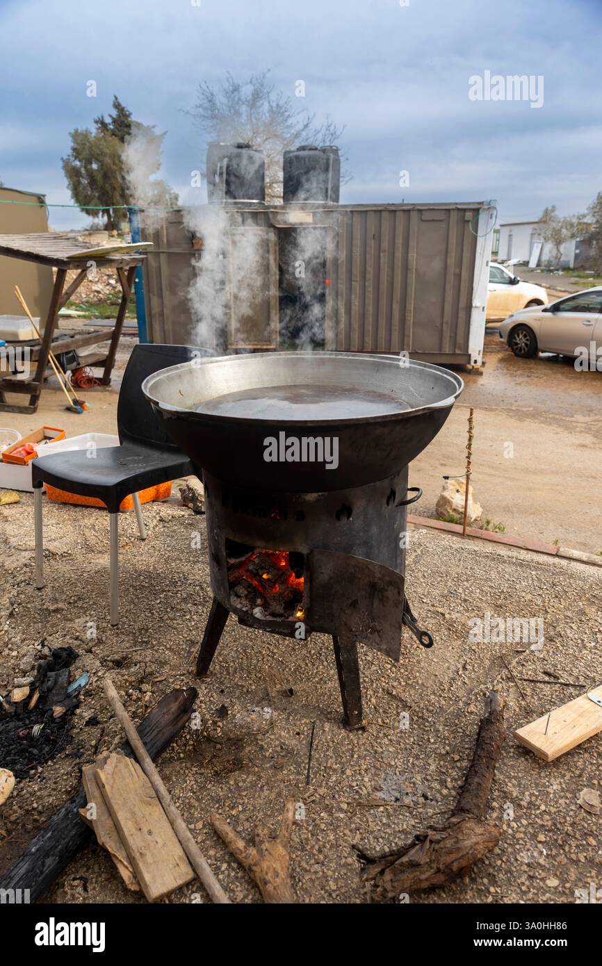 A cauldron of water boiling over an open flame in a street stove Stock ...