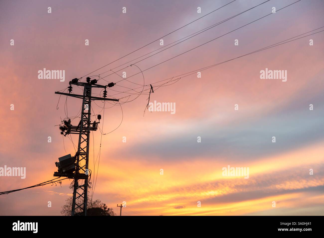 Leaning Power Pole with Tangled Wires Against a Vibrant Sunset Sky ...