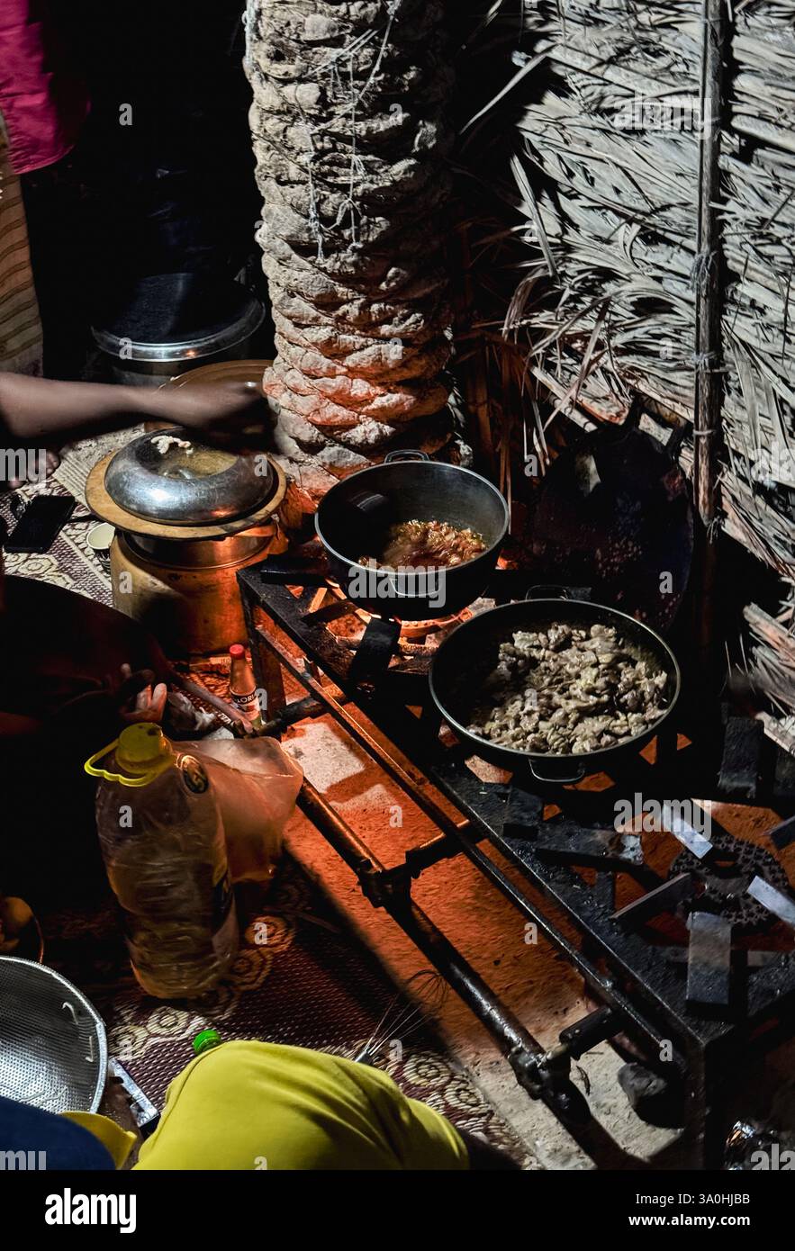 A warm glow illuminates the cooking area as local dishes are prepared ...