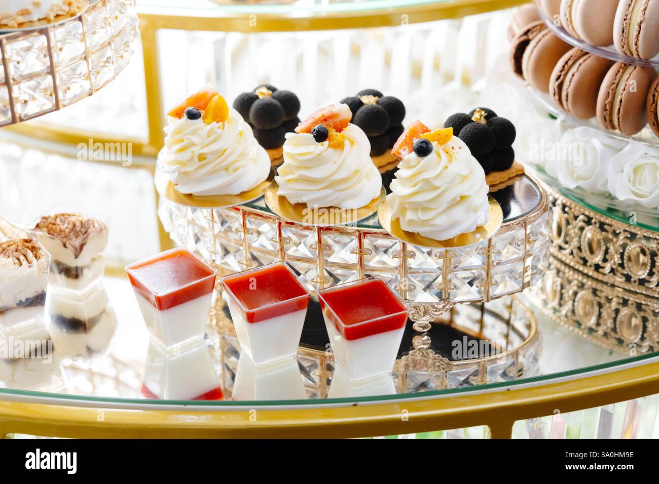 Luxurious candy bar buffet displaying a variety of delicious pastries, macarons, and sweets ...