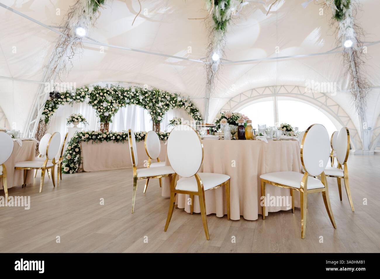 Luxurious wedding setup with round tables, stylish chairs, and ...