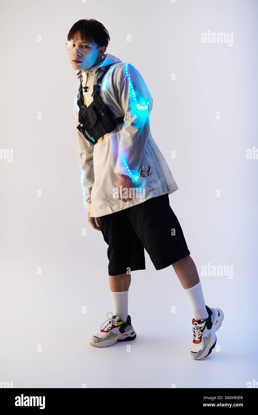 Young Asian man models a trendy outfit featuring glowing elements in a ...