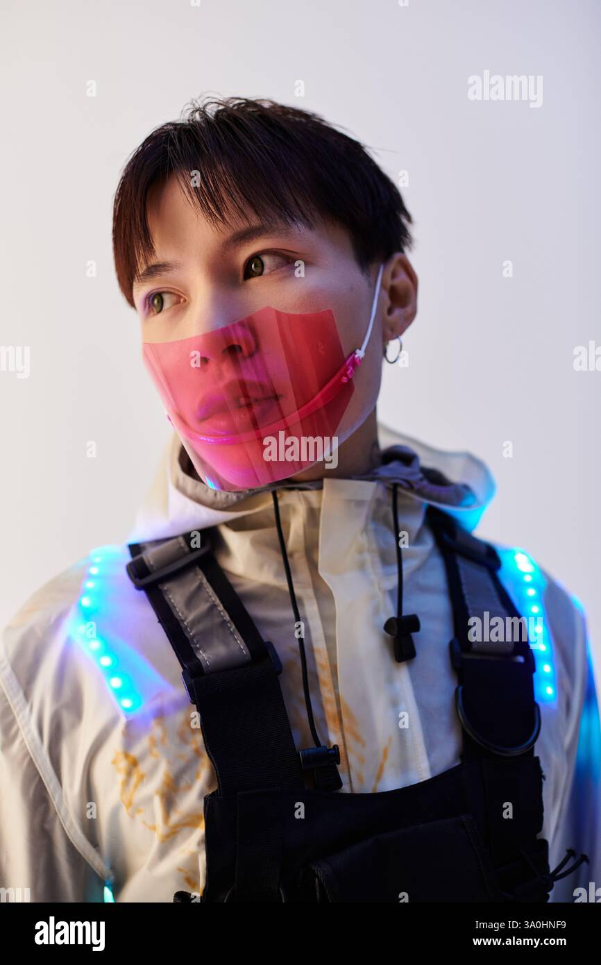 A confident young Asian man in a modern outfit and unique mask ...