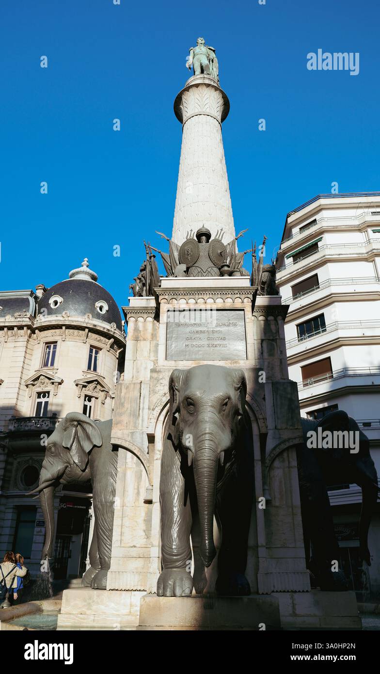 A stunning monument featuring elephants and a tall column under a clear ...