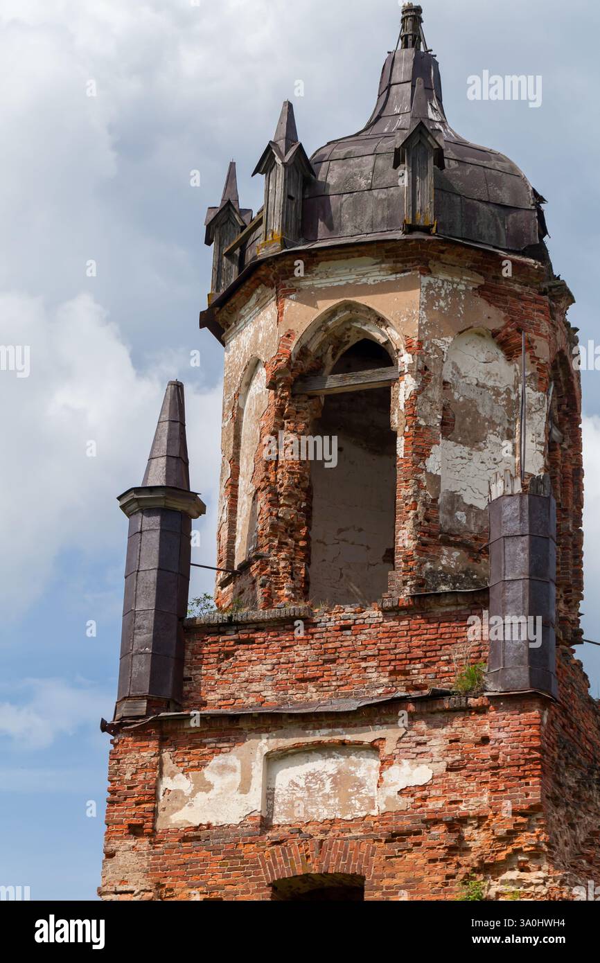 A weathered brick bell tower with gothic architectural details ...