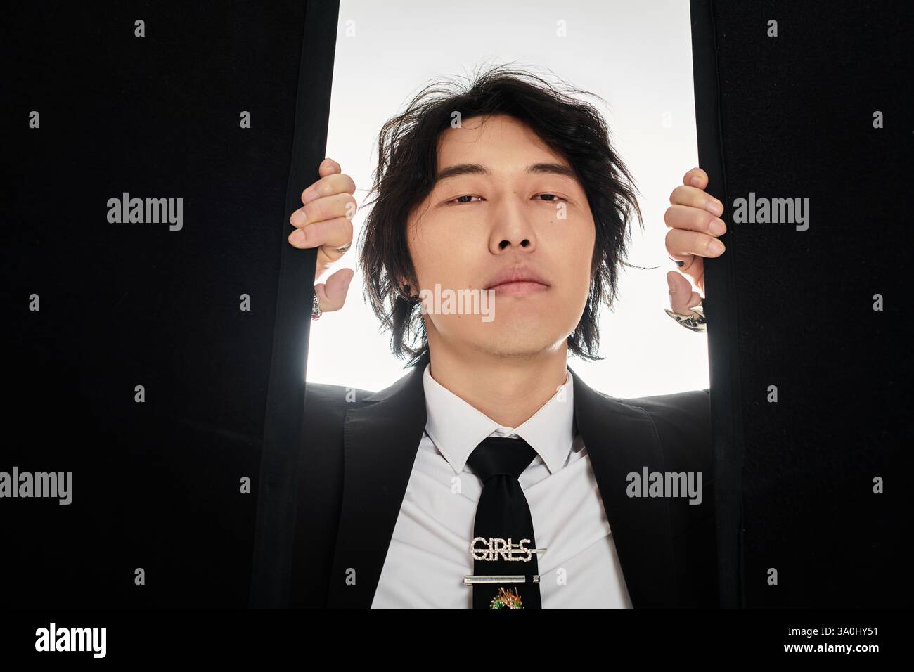A handsome young Asian man in a tailored suit showcases modern urban fashion Stock Photo - Alamy