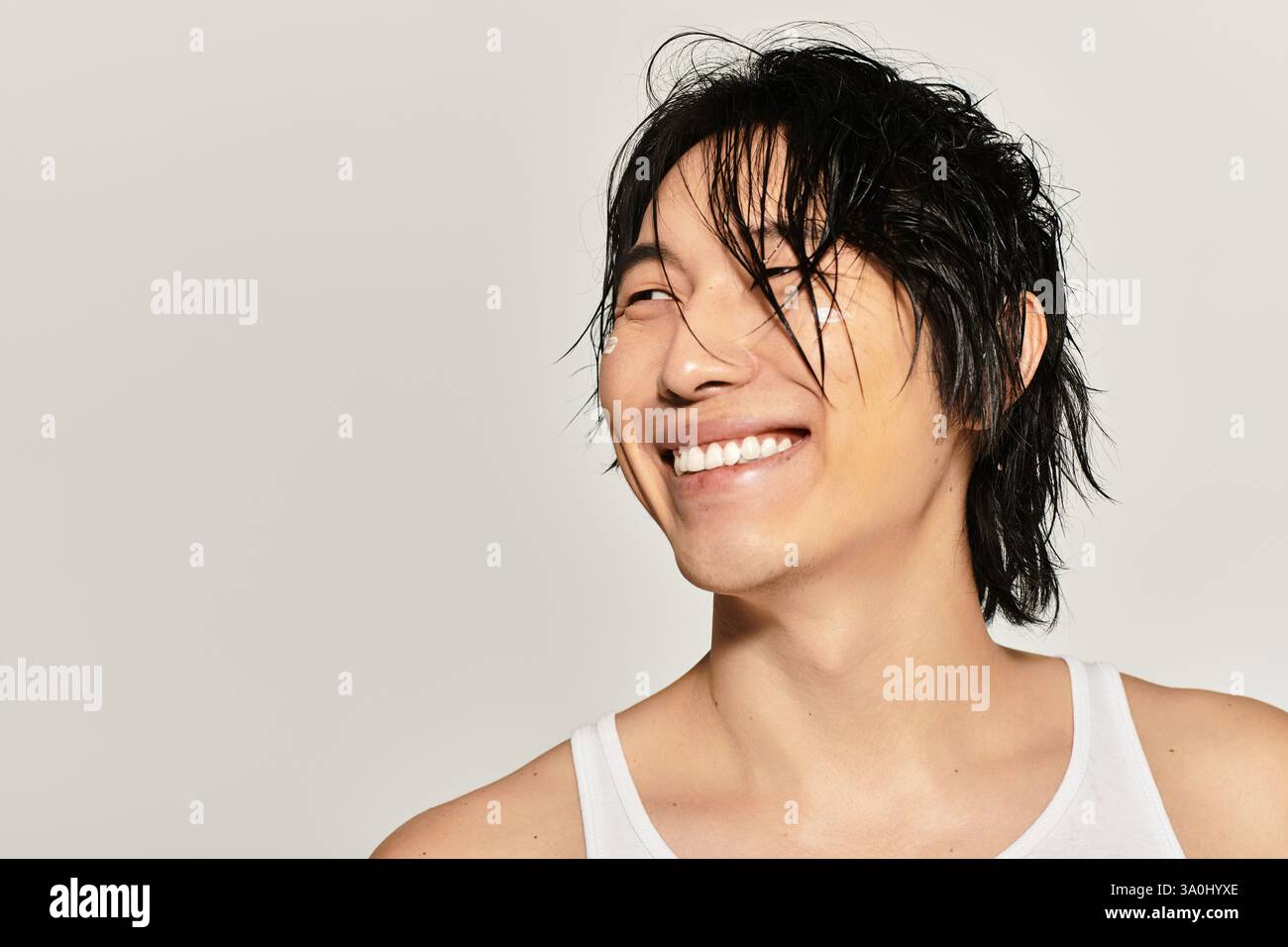 A young asian man showcases his handsome features while posing ...