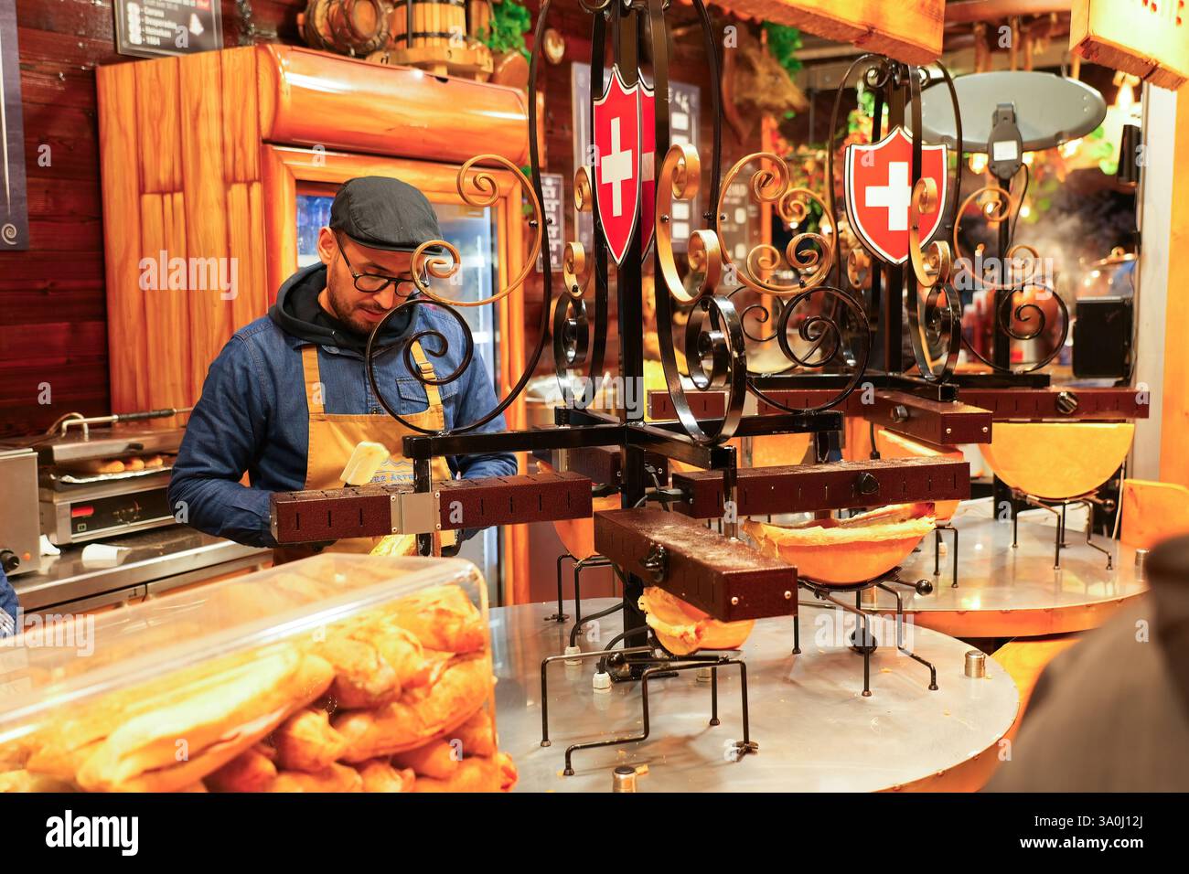 Raclette cheese melting in a booth of Swiss specialties at the ...