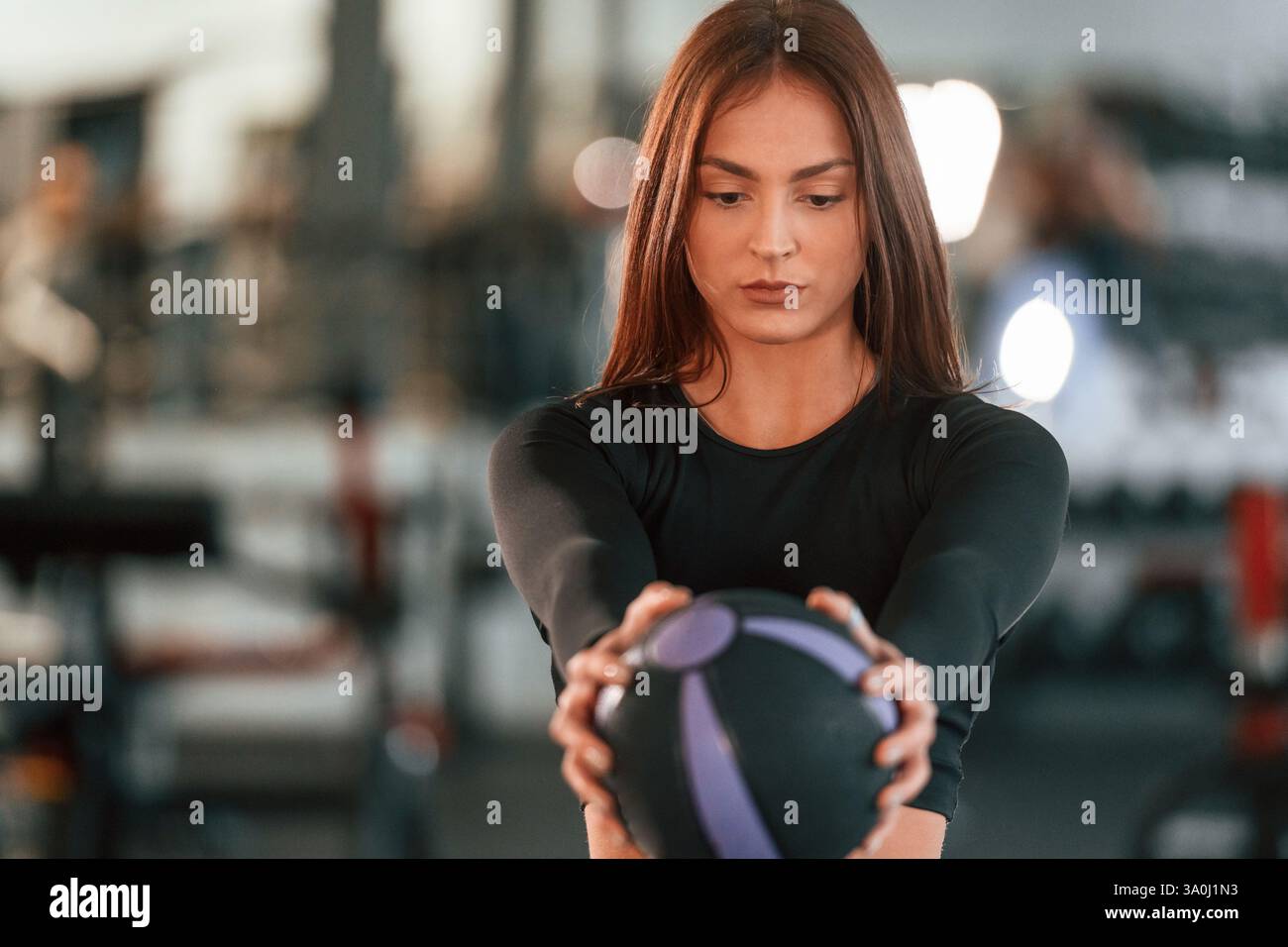 Fitness ball in hands. Standing and posing. Beautiful woman with sport ...