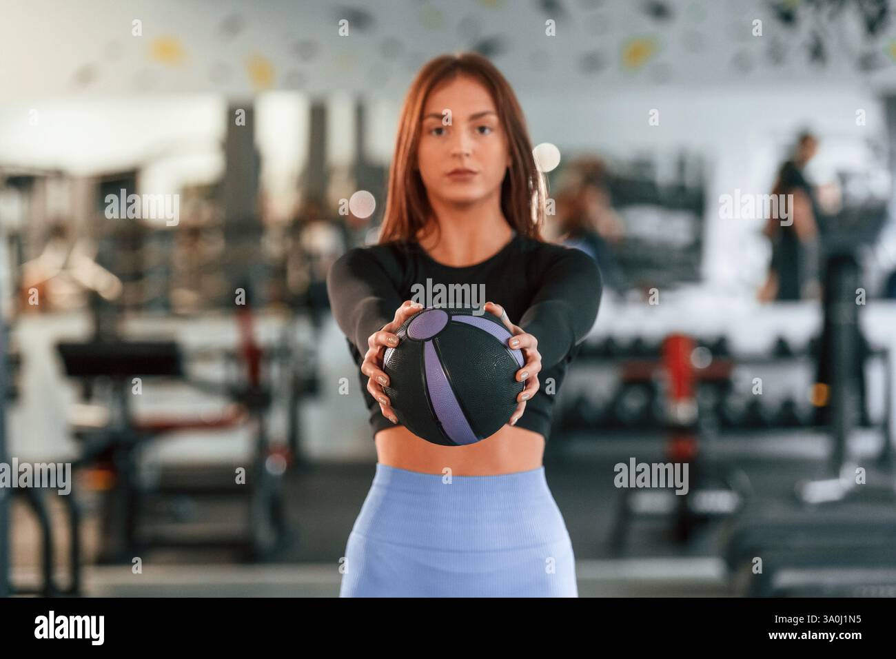 Fitness ball in hands. Standing and posing. Beautiful woman with sport ...
