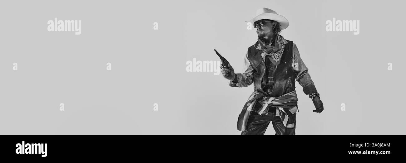 Serious man dressed in black leather pants, denim vest, and red bandana ...