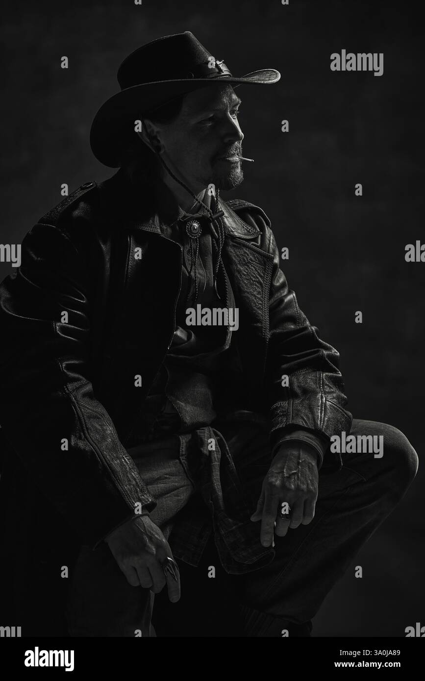 Black and white portrait of rugged cowboy in leather coat and hat ...