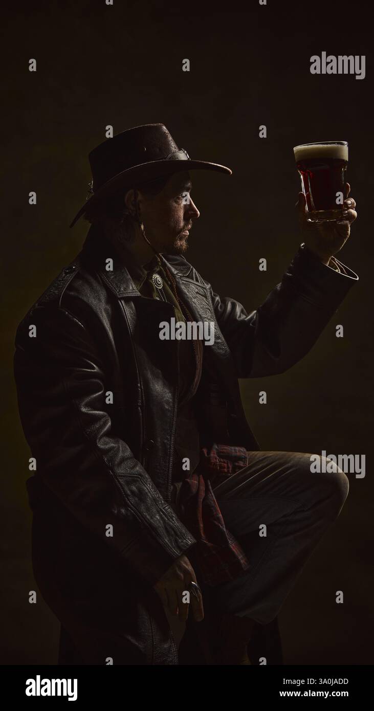 Cowboy raising pint of beer, admiring rich color and foam, dressed in ...