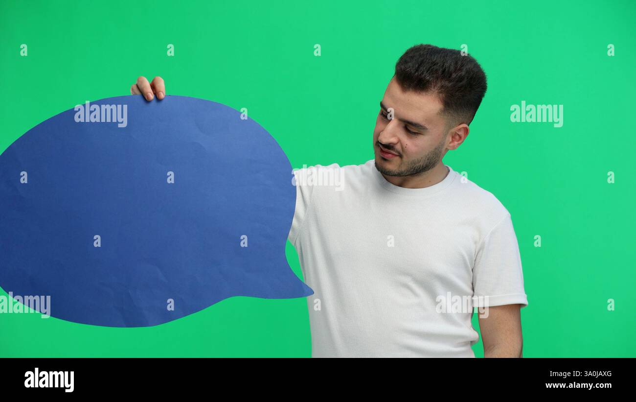 A man, close-up, on a green background, shows a blue comment sign Stock ...