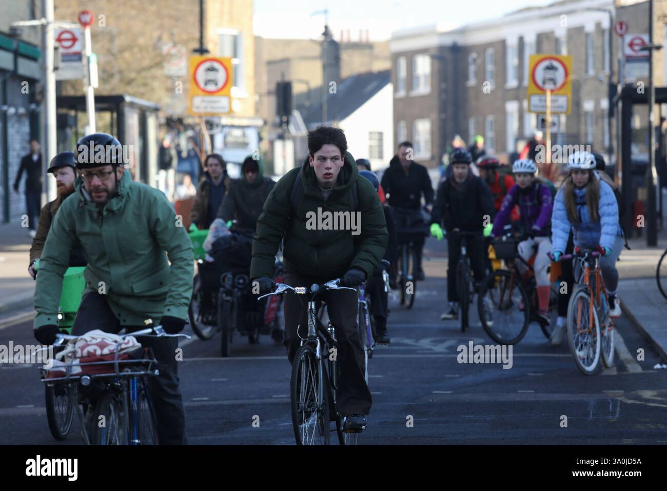 Bike riders commuting to work in the early morning sun. The bikes are a ...