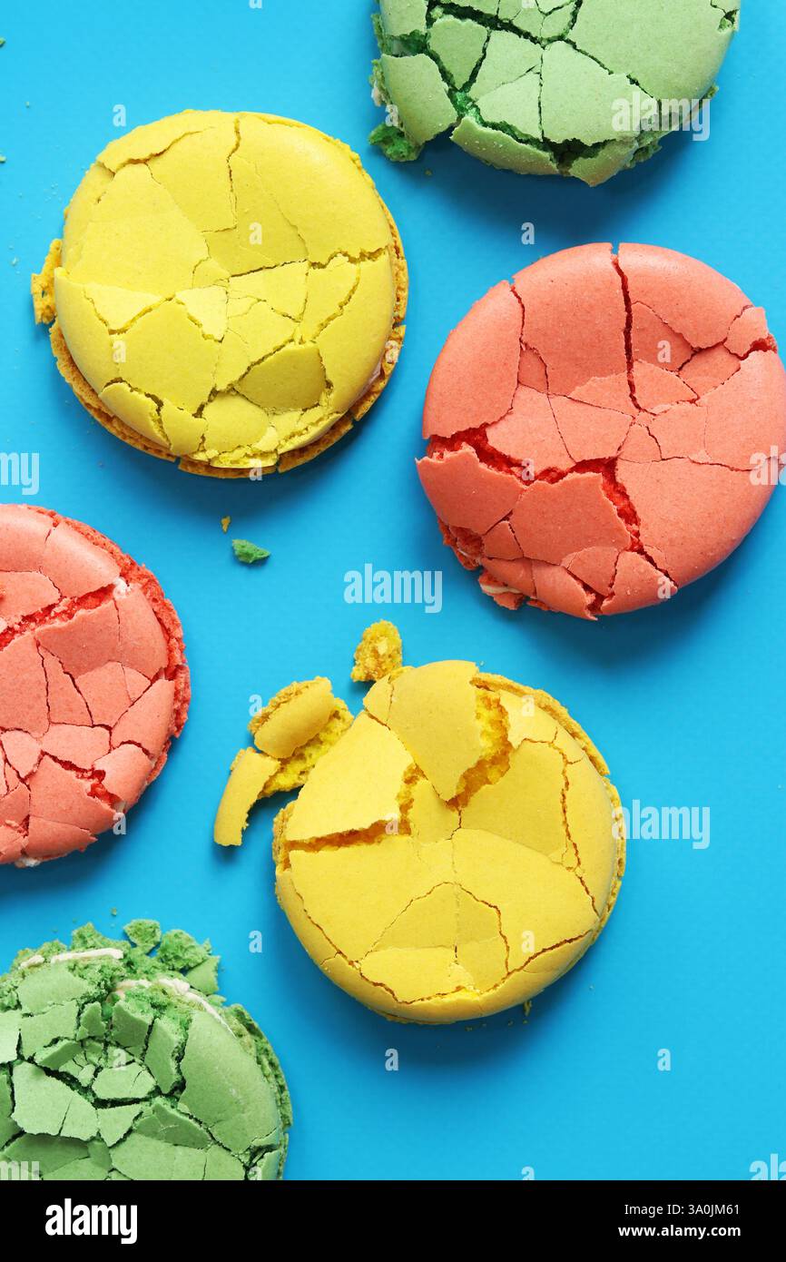 Bright multi-colored French macarons on a blue background, top view ...