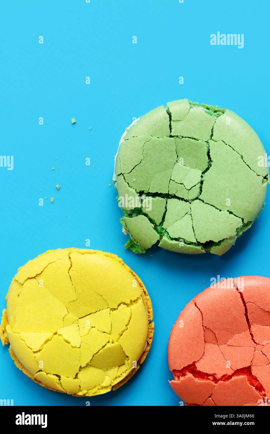 Bright multi-colored French macarons on a blue background, top view ...