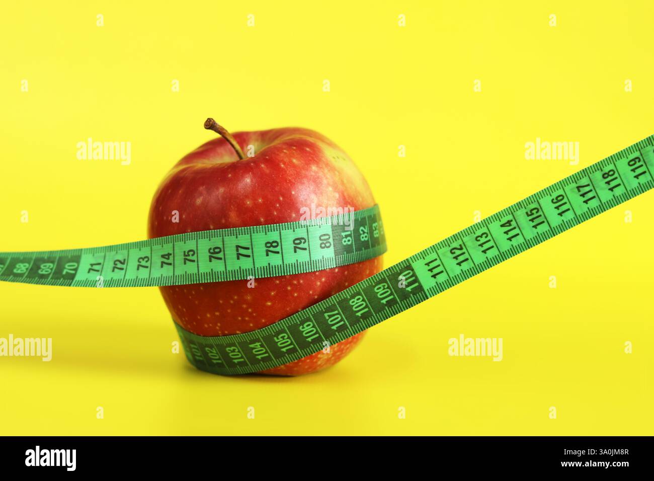Measuring tape wrapped around an apple. Metaphor - round figure. Ripe ...