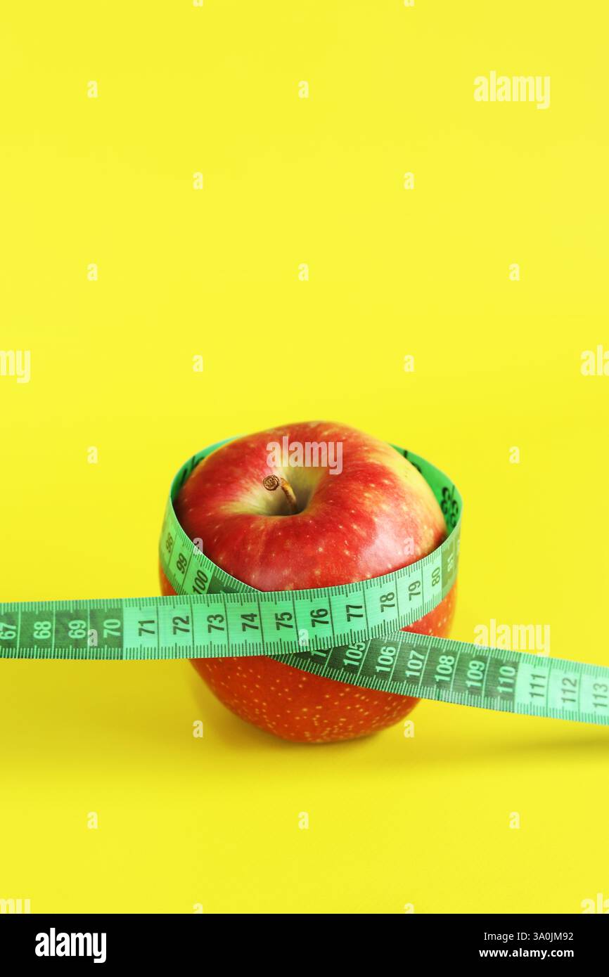 Measuring tape wrapped around an apple. Metaphor - round figure. Ripe ...