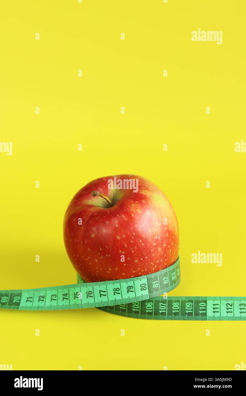 Measuring tape wrapped around an apple. Metaphor - round figure. Ripe ...