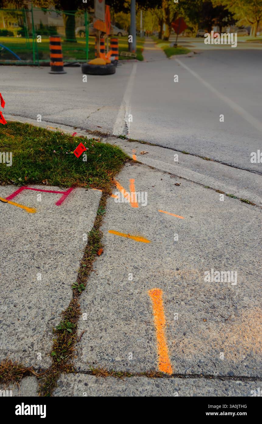 Sidewalk markings at a road construction site showing underground ...