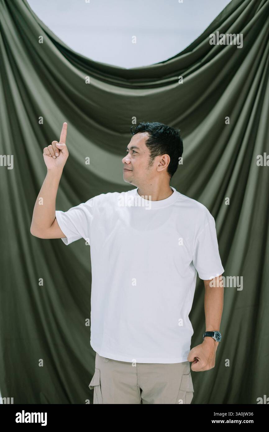 A man indicating an idea with his index finger, wearing a casual white ...