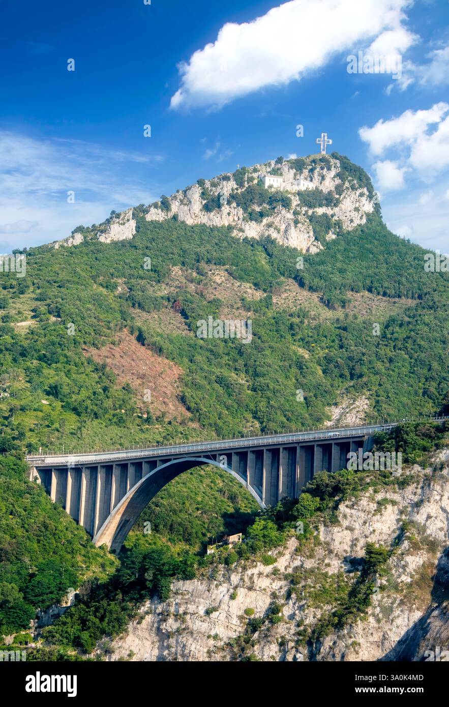 Cross and top of mountain peak, and a bridge crossing the gorge in the ...