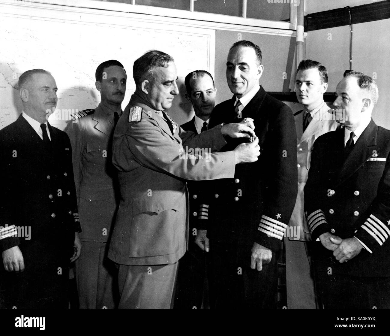 Rear Admiral Daniel E. Barbey, USN, Commander Seventh Amphibious Force, Seventh Fleet, presents ...