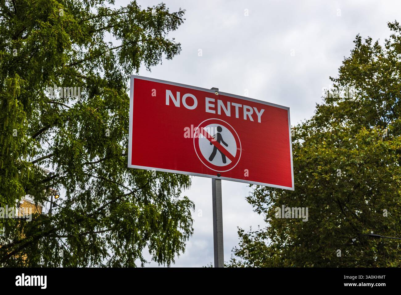 No entry sign with a prohibition symbol against a natural outdoor ...