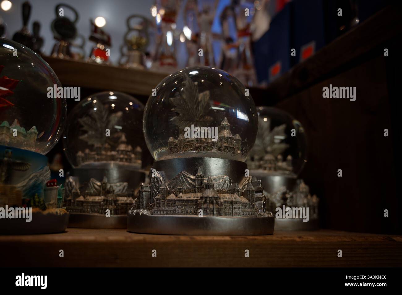 Vintage snow globes of Canada’s landmarks rest in a dimly lit souvenir ...